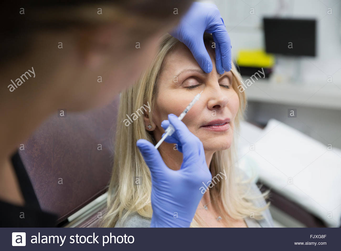Technician giving woman botox injection side of nose Stock Photo - Alamy