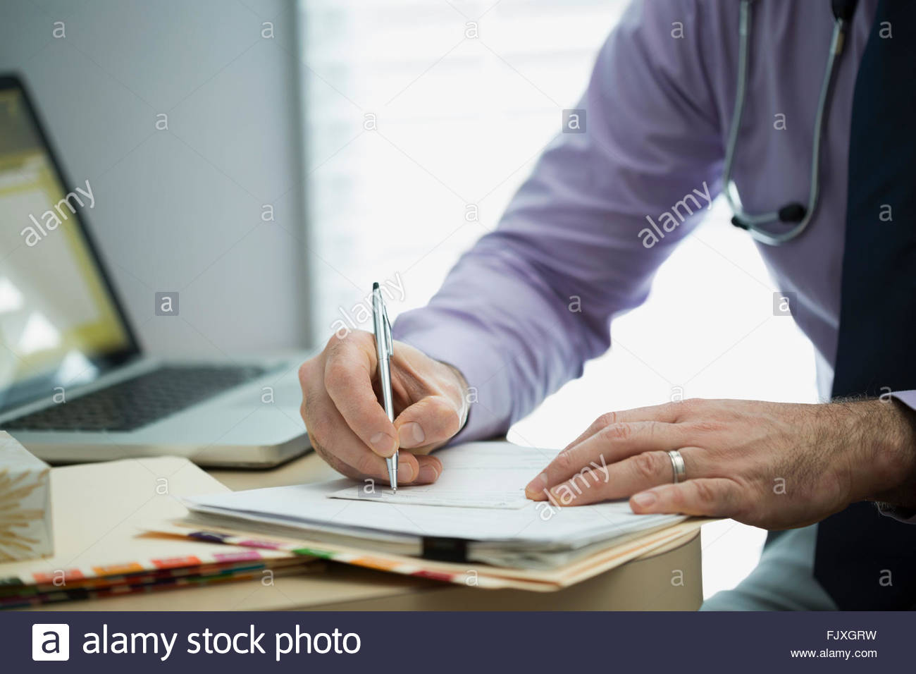 Doctor writing on medical chart hi-res stock photography and images - Alamy