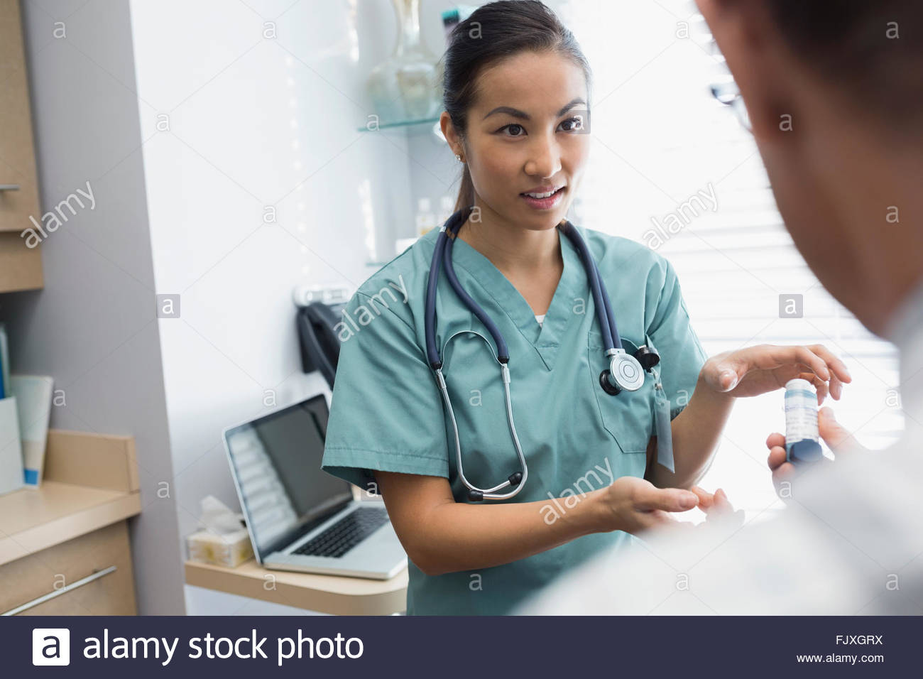Nurse explaining inhaler to patient in examination room Stock Photo - Alamy
