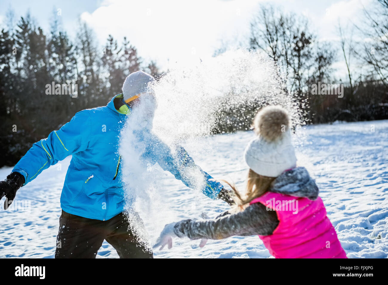 Father and daughter playing snowball fight Stock Photo - Alamy