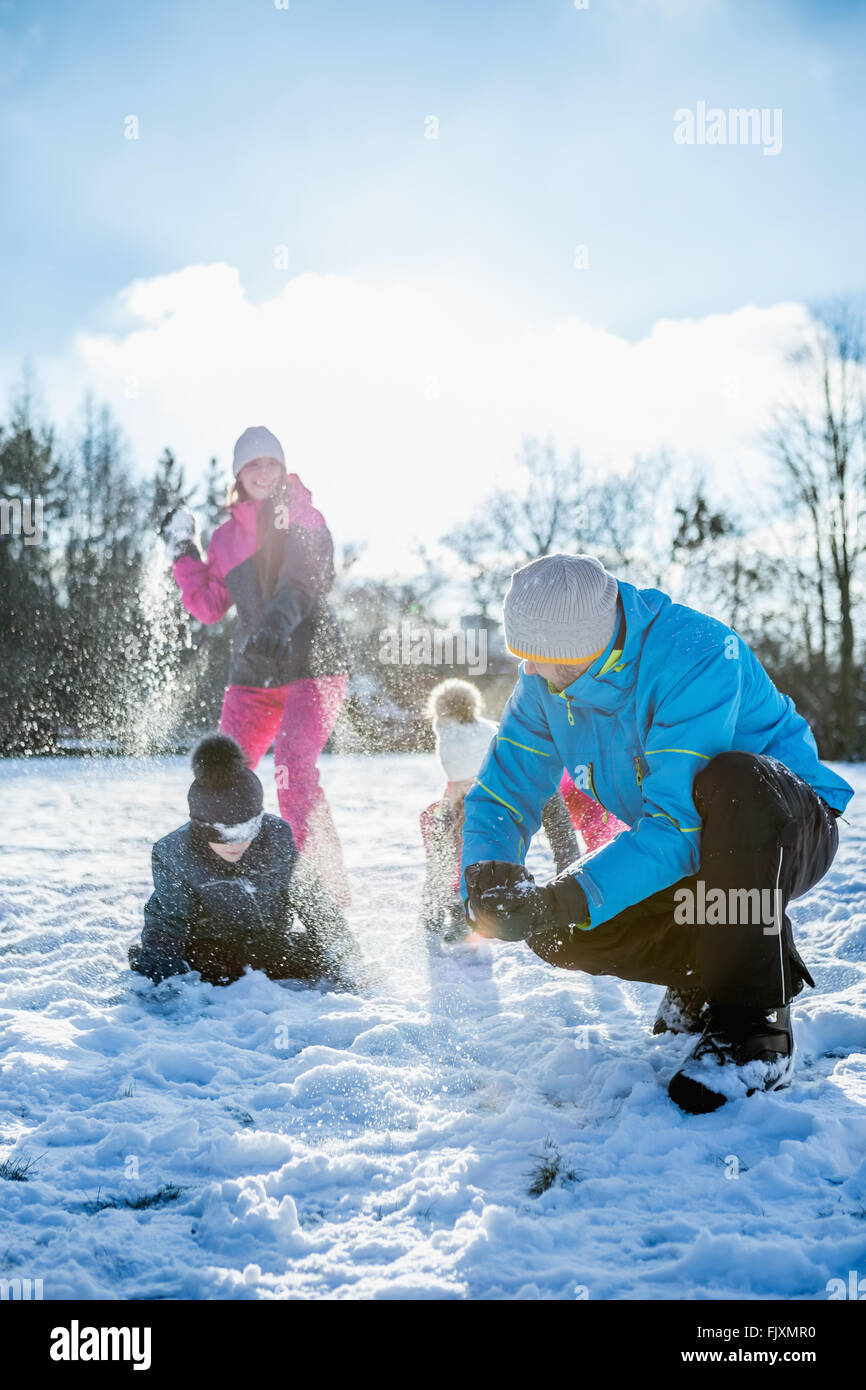 Family playing snowball fight Stock Photo - Alamy