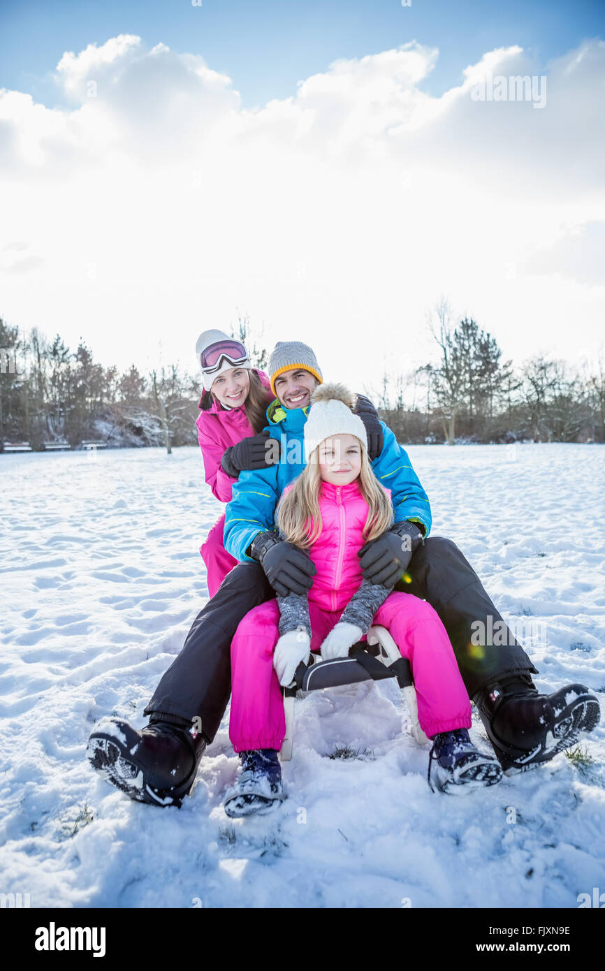 Family sitting on a sleigh Stock Photo - Alamy