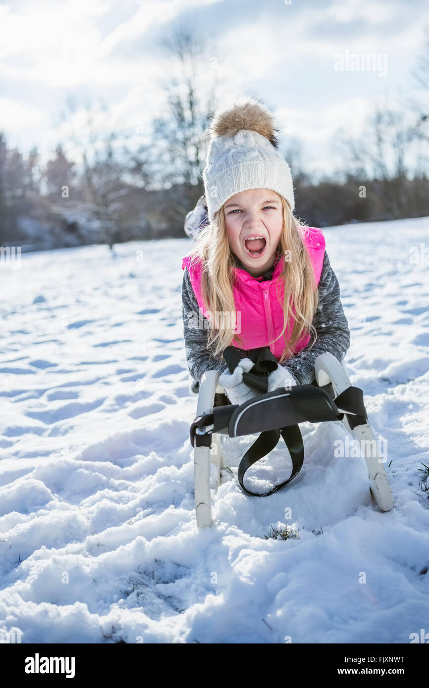 Cute girl playing with sled Stock Photo - Alamy