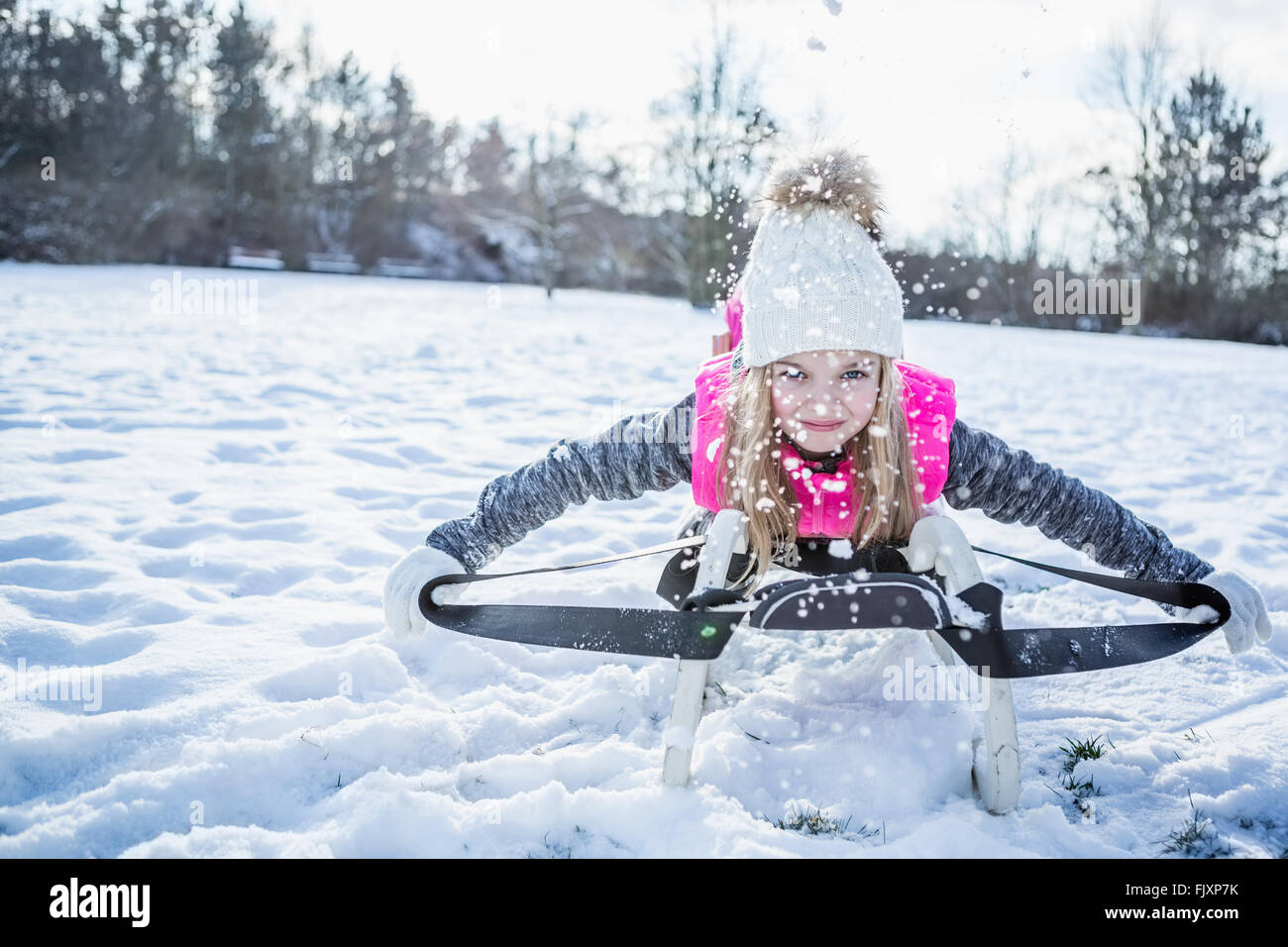 Cute girl playing with sled Stock Photo - Alamy