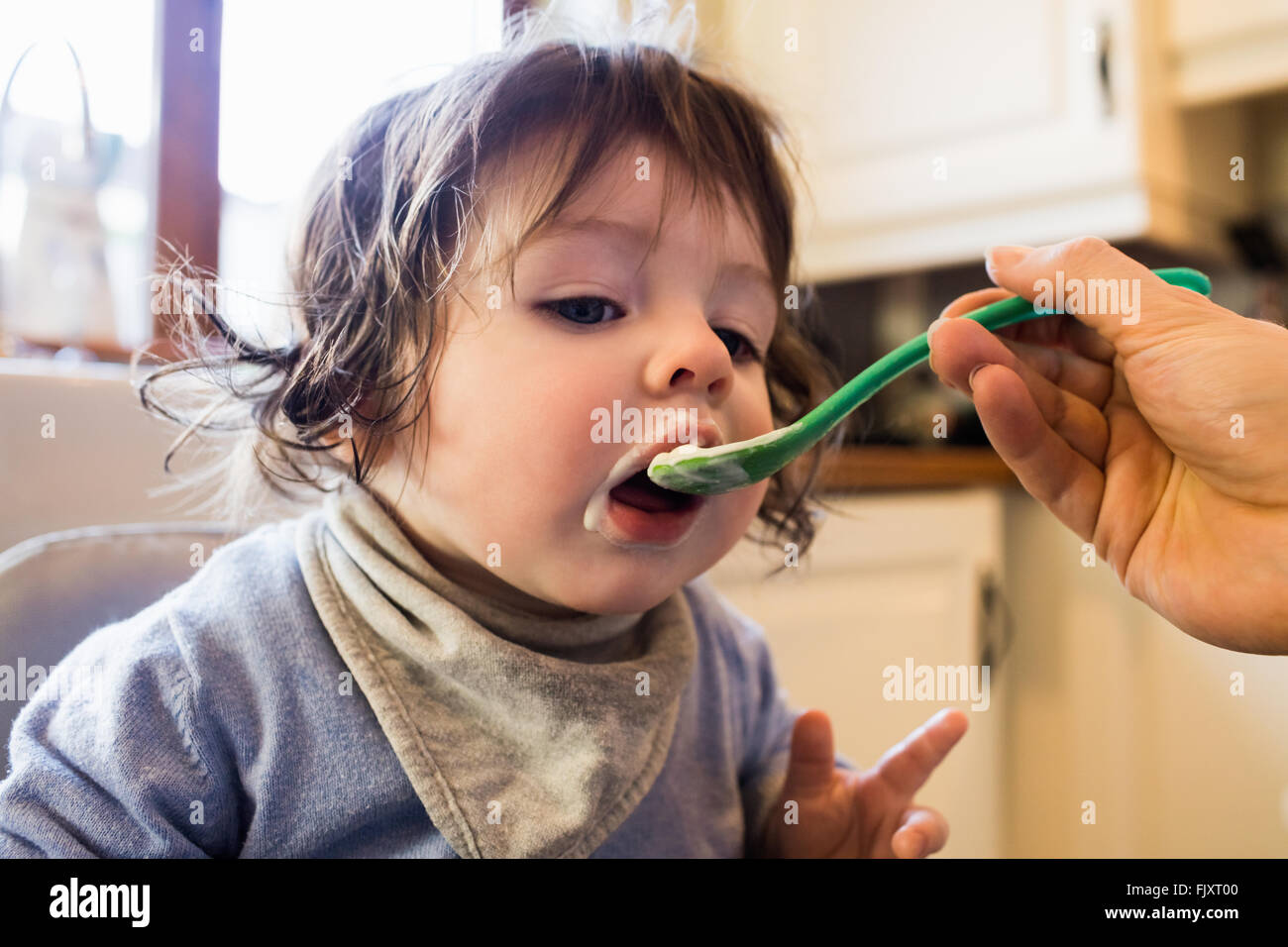 Cute baby being fed by his mother Stock Photo - Alamy