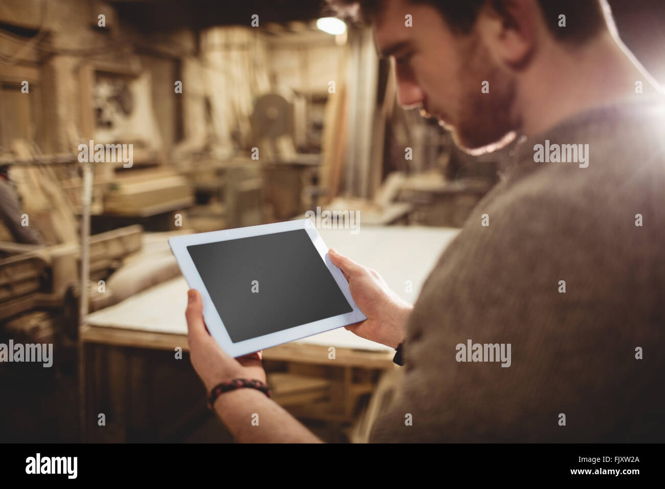 Happy carpenter using his tablet Stock Photo - Alamy
