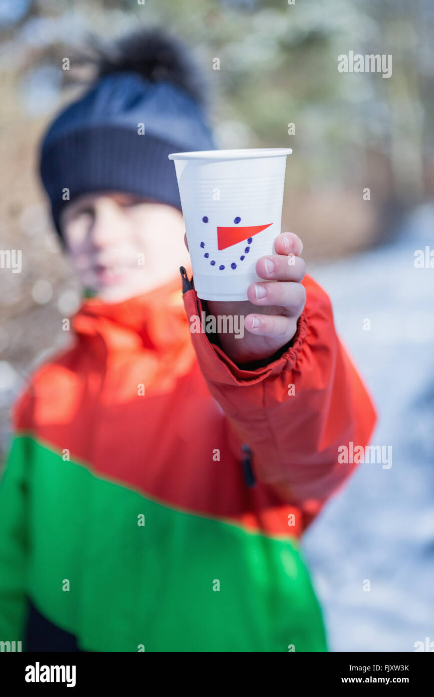 Cute boy showing cup Stock Photo - Alamy