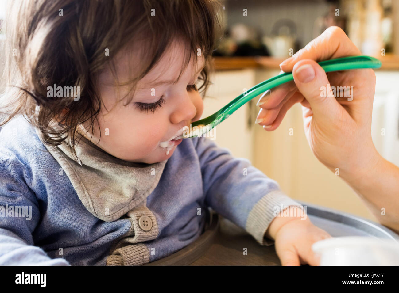 Cute baby being fed by his mother Stock Photo - Alamy