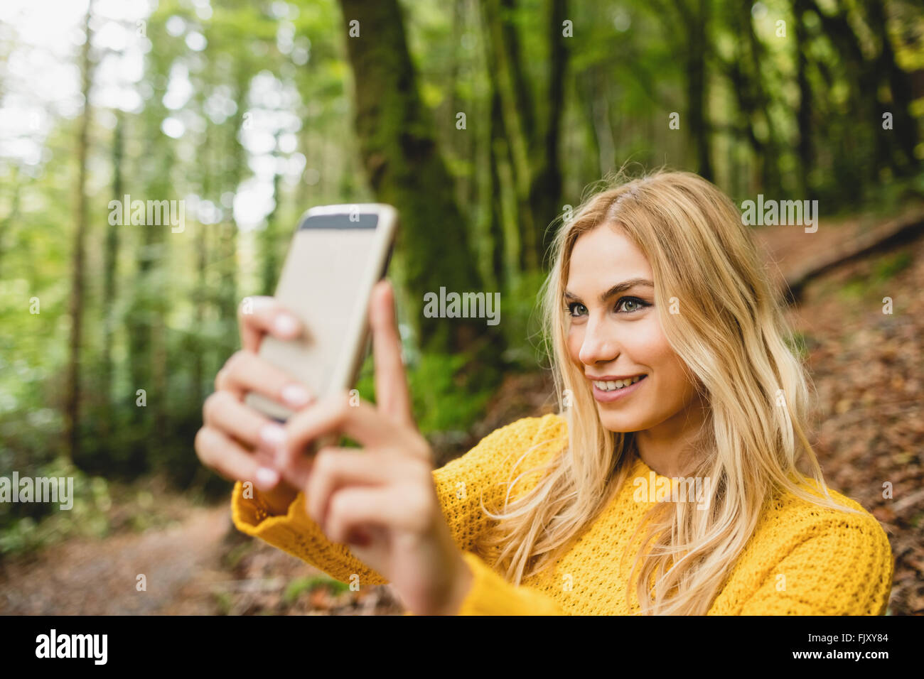Beautiful blonde woman taking picture Stock Photo - Alamy