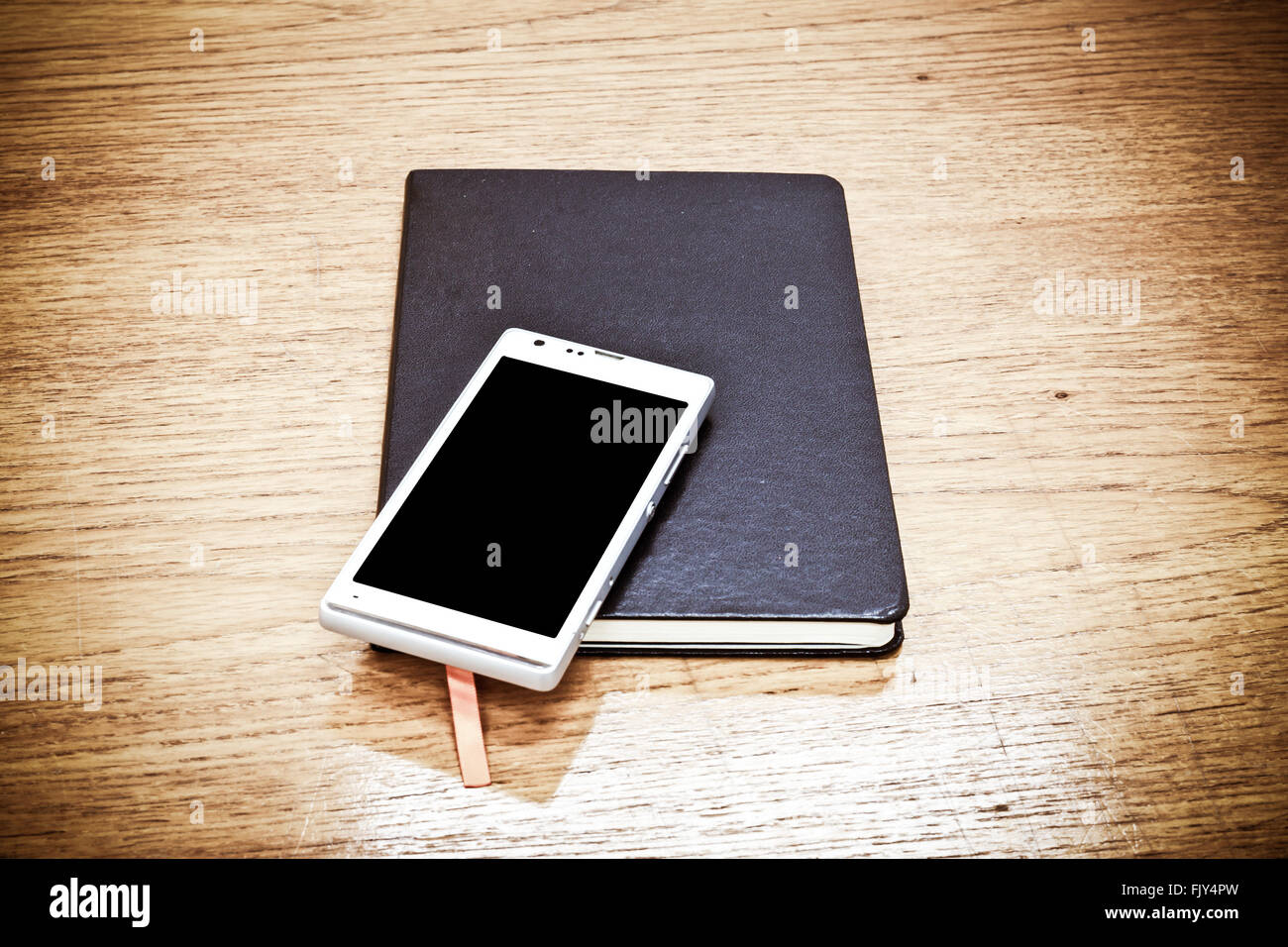 Black leather business diary and Mobile phone on wood table background ...