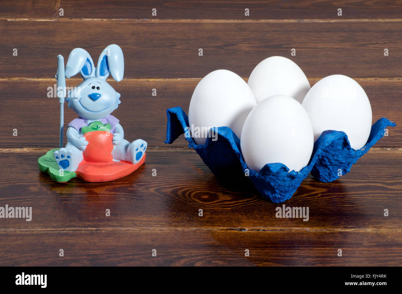 White easter eggs in stand with bunny over wooden background Stock ...