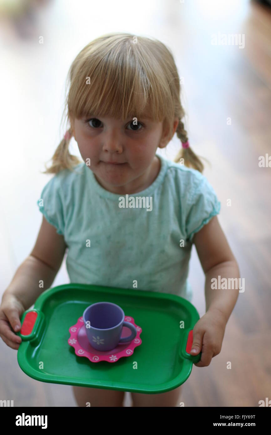 Little girl child kid making Tea holding a tray with a plastic cup and ...