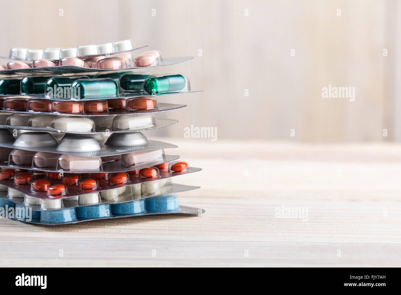 Pills and capsule pile in aluminum container and wooden background ...