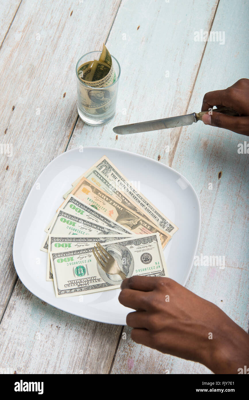 hand eating banknotes symbolising consumerism and corruption Stock ...