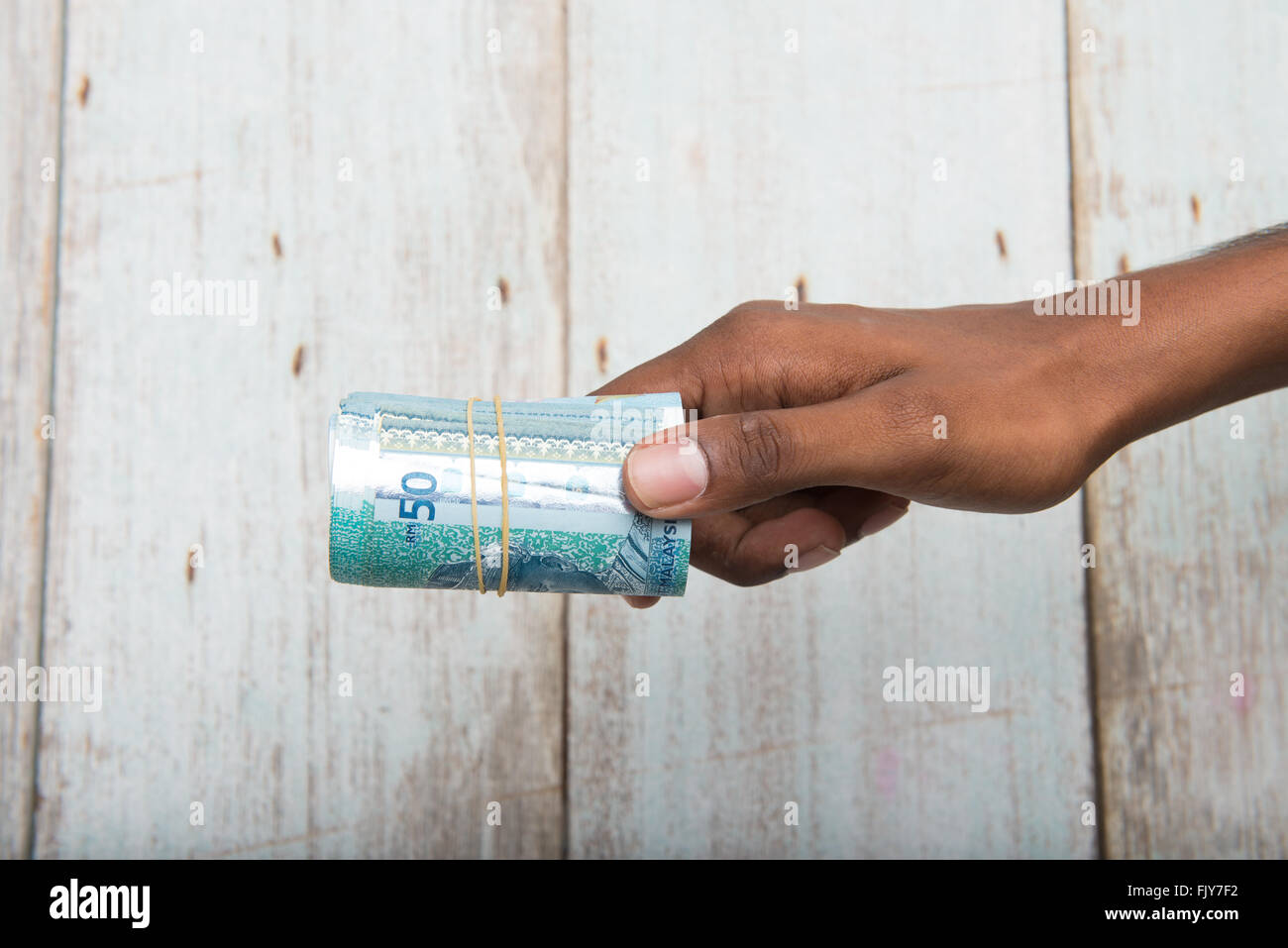 Handing out money in Malaysia ringgit , dark tone skin Stock Photo - Alamy