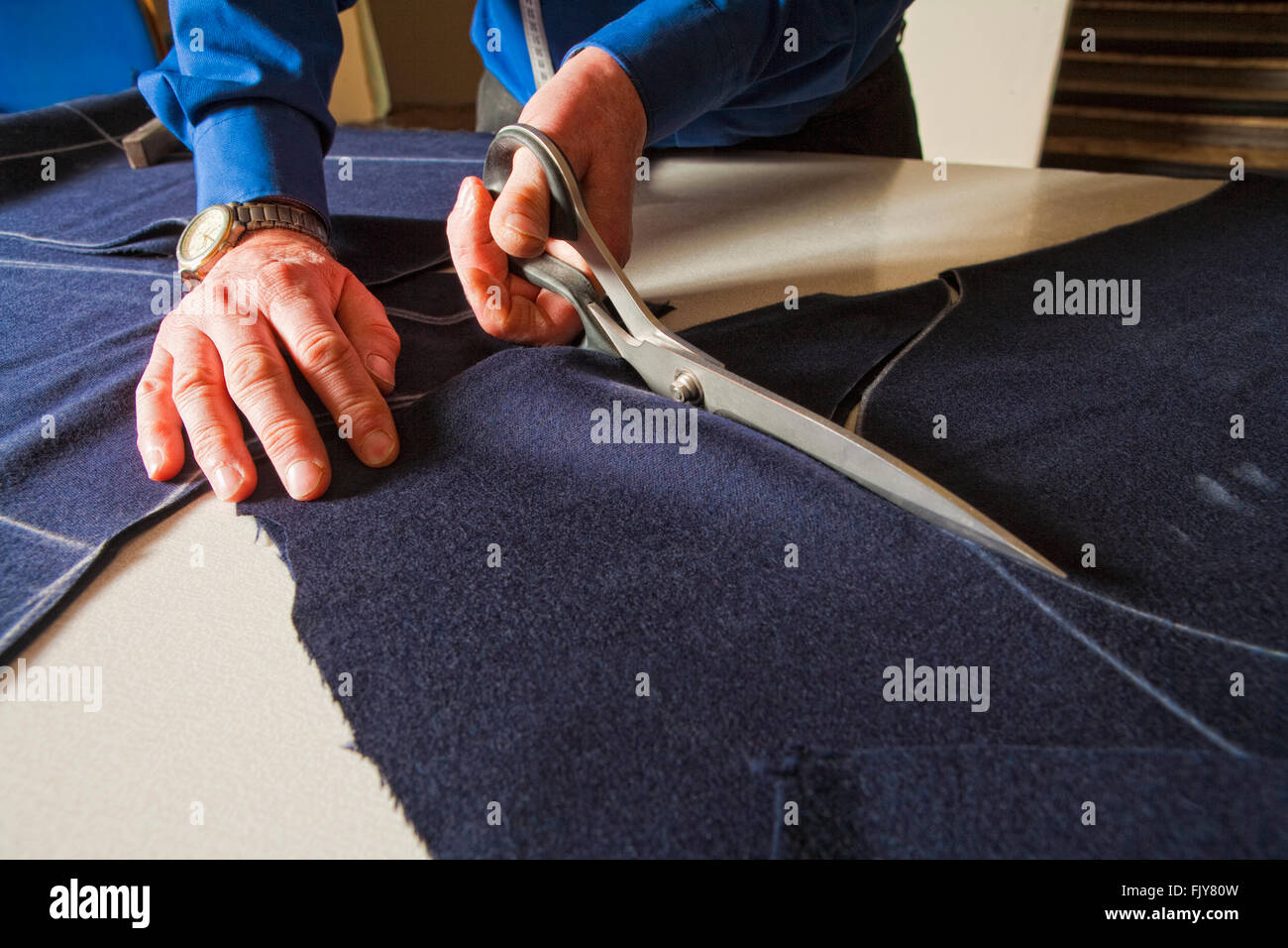 Tailor Cutting Fabric to a New Coat with Scissors Stock Photo - Alamy