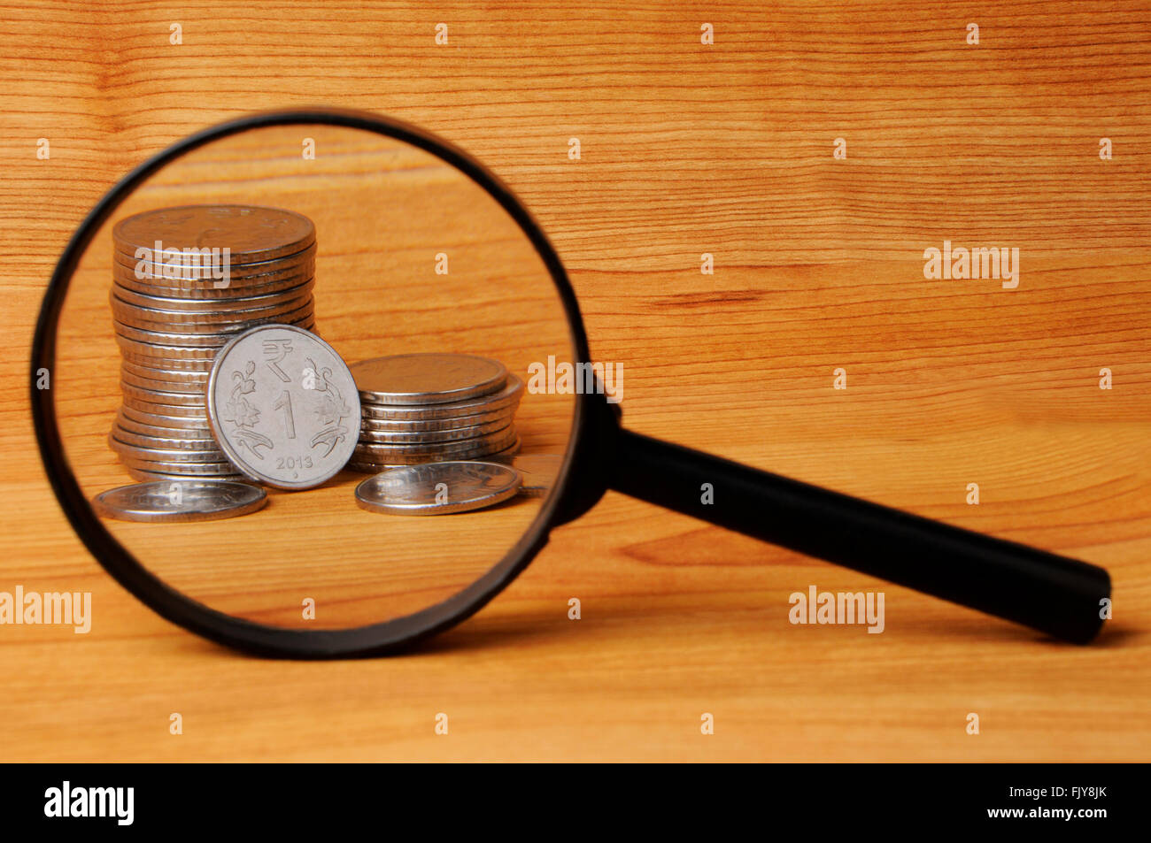 Magnifier and coins Stock Photo - Alamy