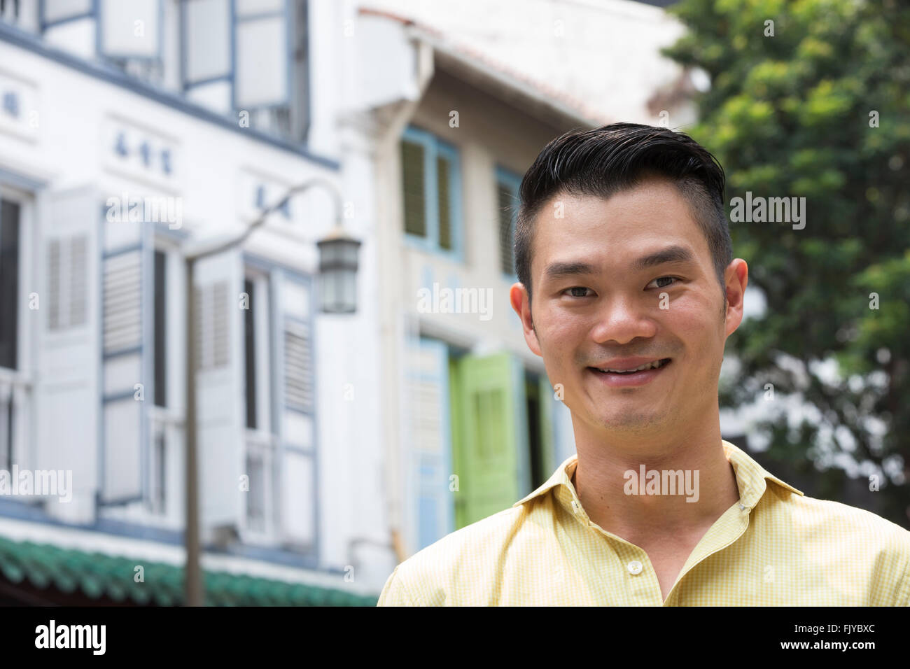 Portrait of a trendy urban Chinese man. Happy Asian man in city looking ...