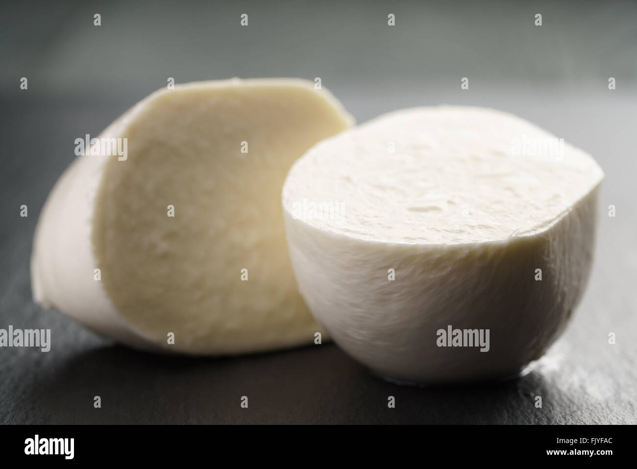 sliced mozarella ball on slate background Stock Photo - Alamy