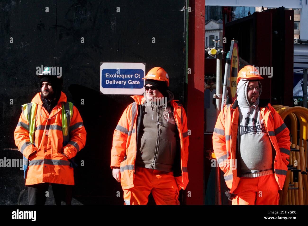 Workers stand outside a construction site in the City of London ...