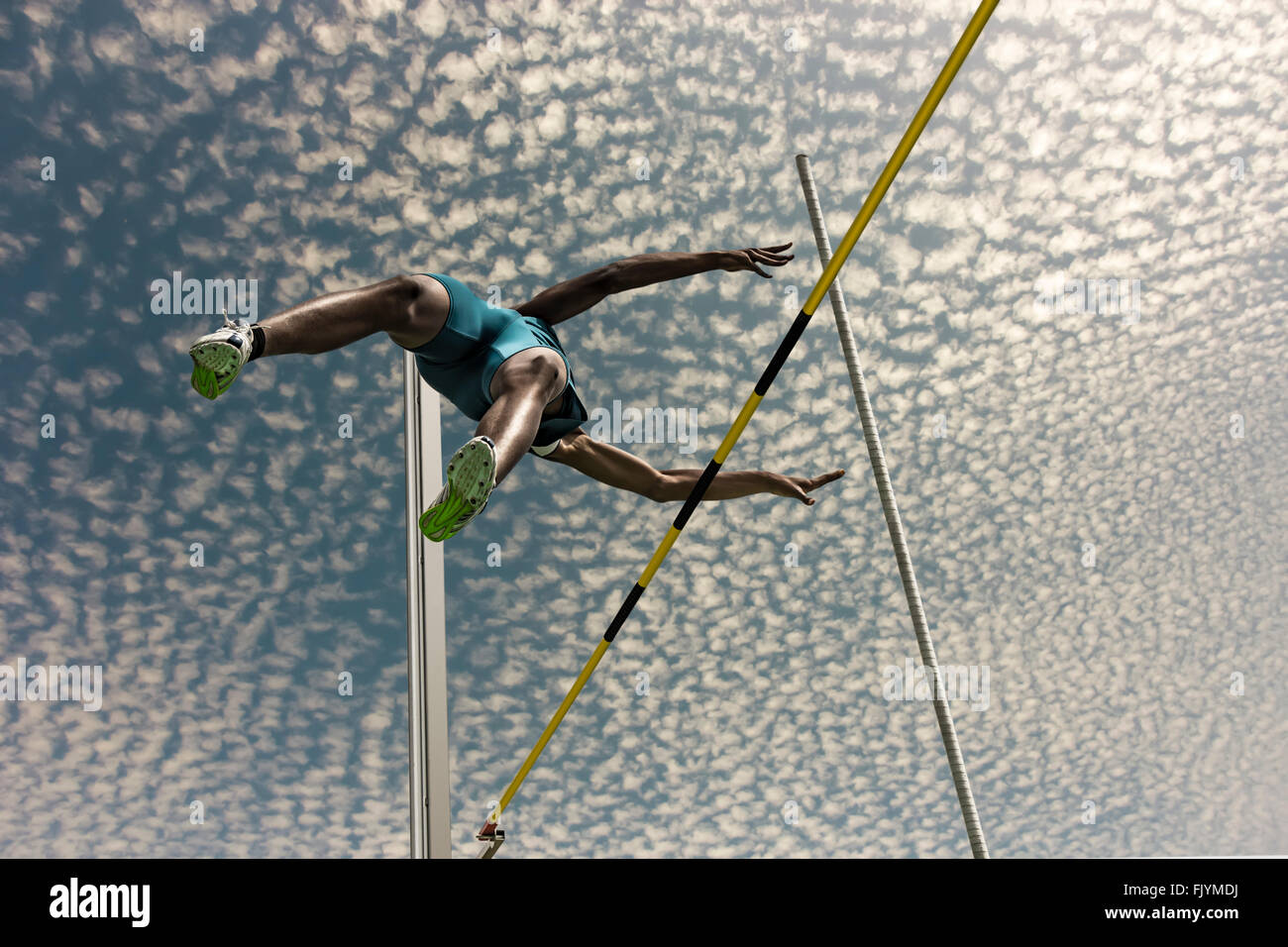 Male pole vaulter jumps over the yellow black striped bar Stock Photo ...