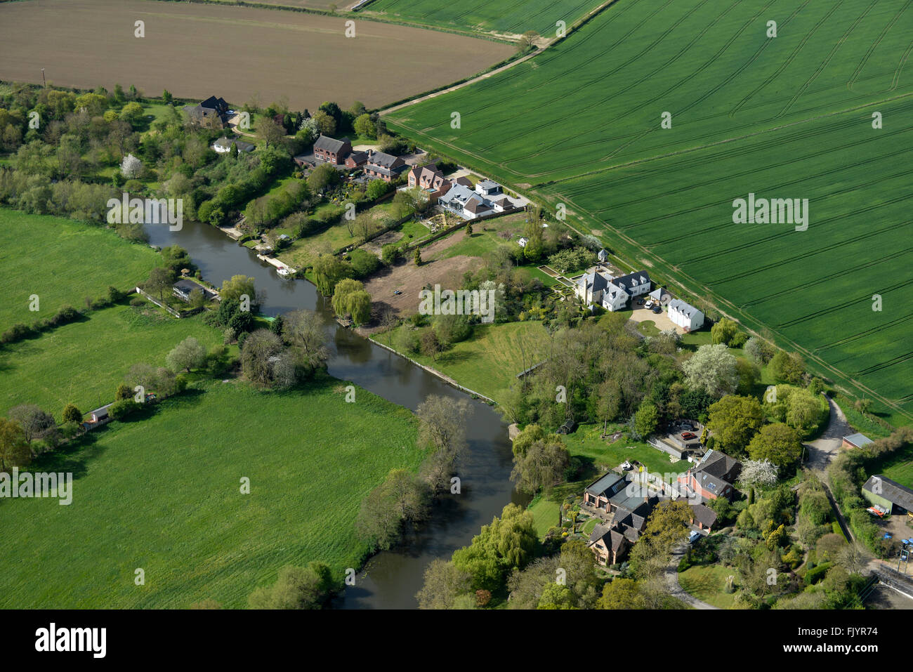 An aerial view of some large houses near a river in the English ...