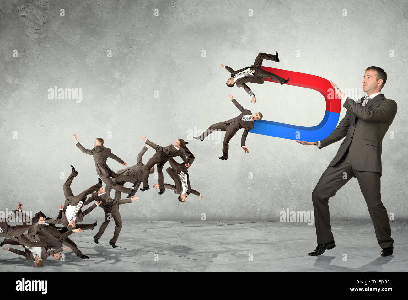 Businessman catching people within magnet Stock Photo - Alamy