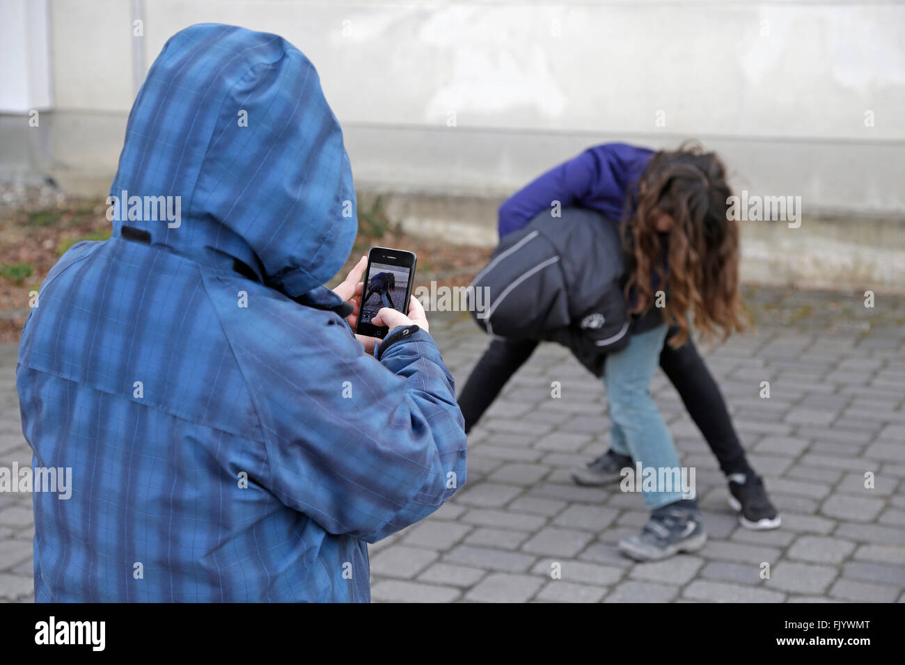 two kids fighting, third one making video with smartphone Stock Photo ...