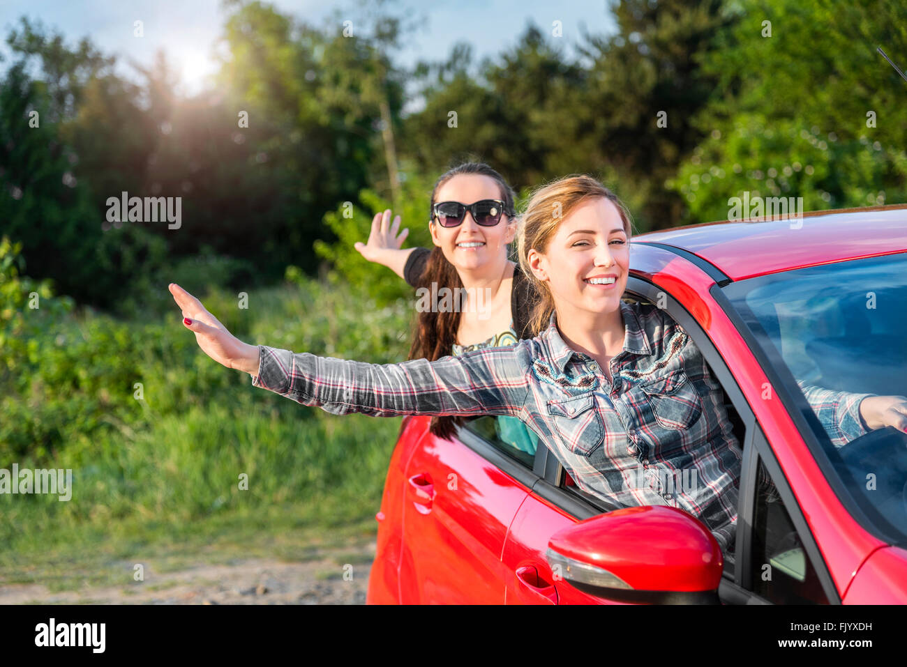 Girls in a red car at sunset. Travel concept Stock Photo - Alamy