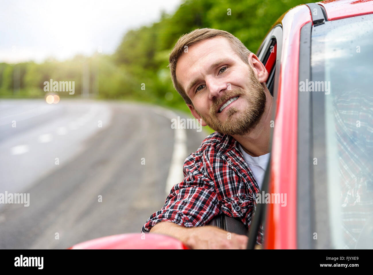 Driver man in new red car on the road Stock Photo - Alamy