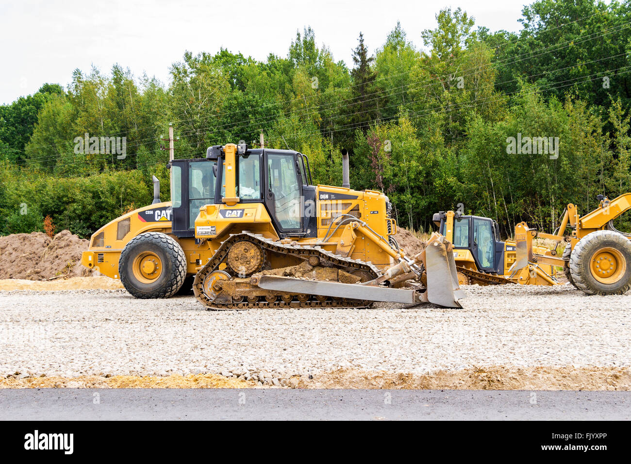 Heavy bulldozer loading and moving gravel on road construction site ...