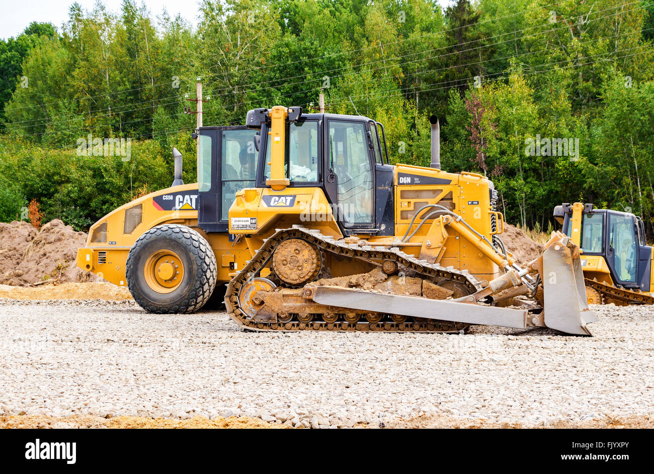 Heavy bulldozer loading and moving gravel on road construction site ...