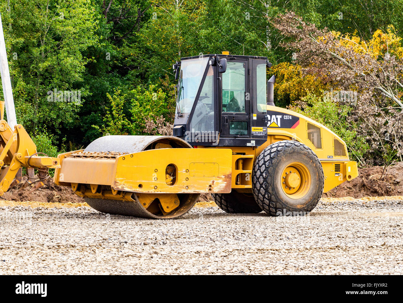 Heavy bulldozer loading and moving gravel on road construction site ...