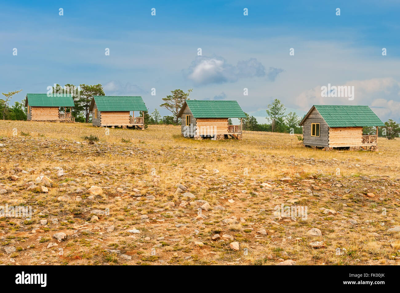 Wooden cottages in field with blue sky Stock Photo - Alamy