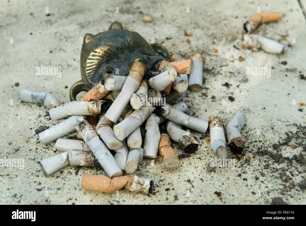 Over flowing ashtray in the shape of a human face and numerous ...