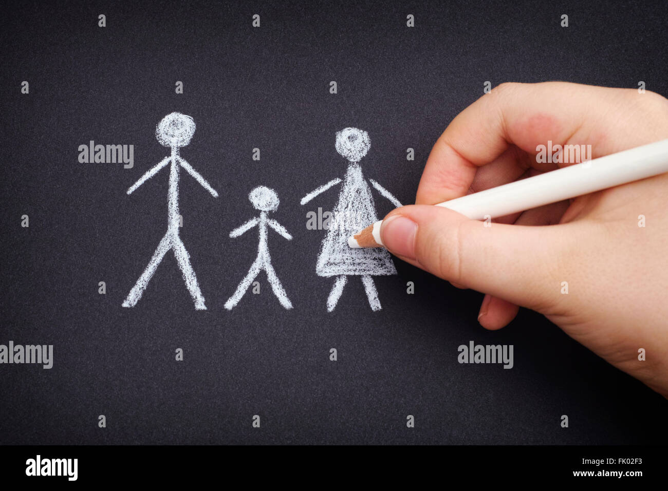Child drawing family on black paper. Close up Stock Photo - Alamy