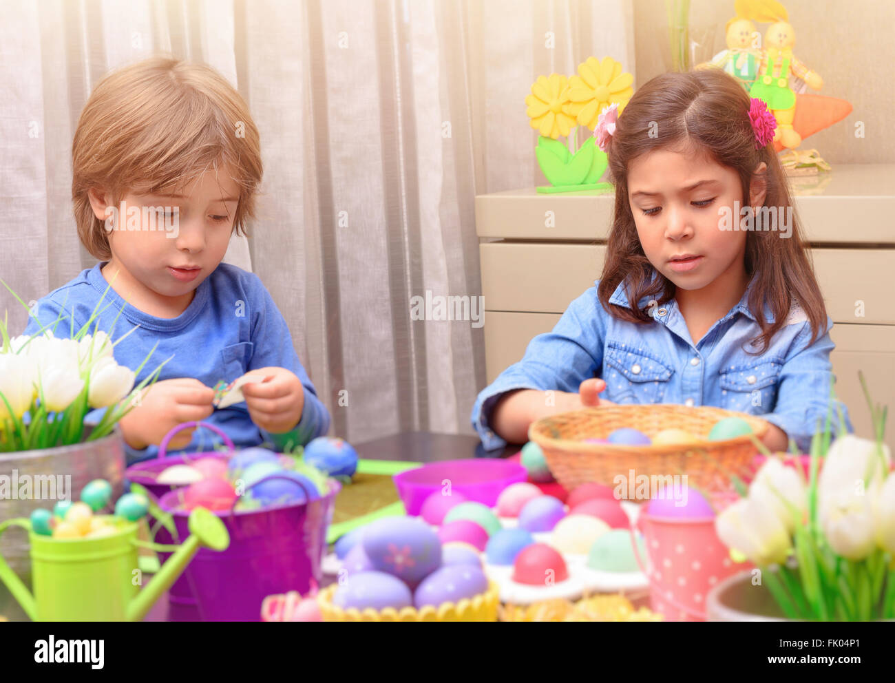 Portrait of little brother and sister painting traditional Easter eggs ...