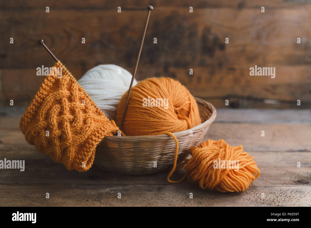 Balls of yarn in basket with knitting needles Stock Photo - Alamy