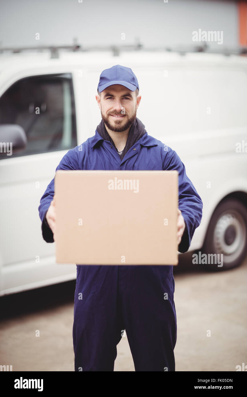 Delivery man holding box Stock Photo - Alamy