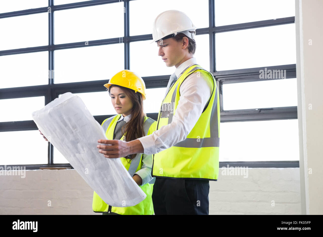Architects looking at blueprint Stock Photo - Alamy