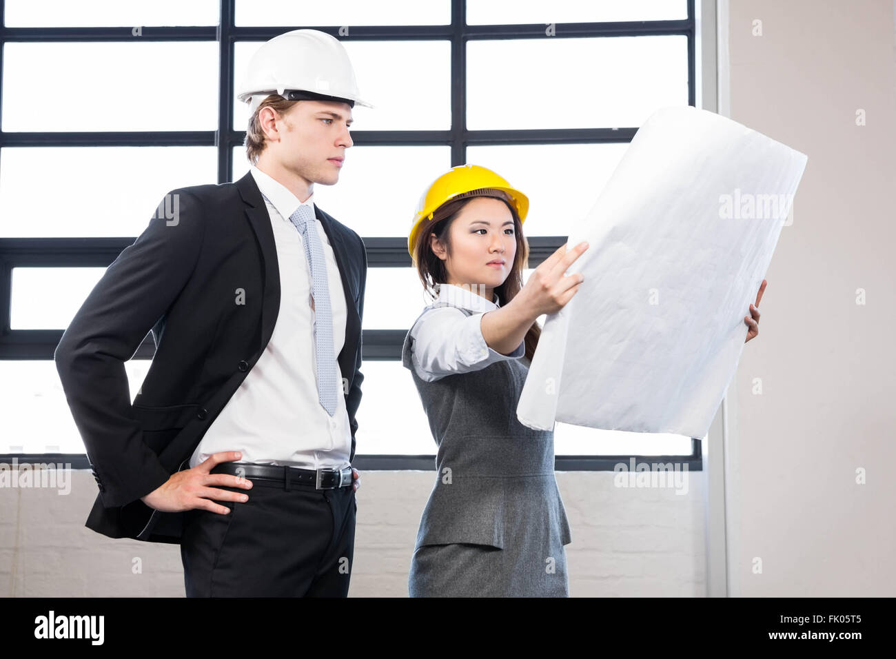 Architects looking at blueprint Stock Photo - Alamy