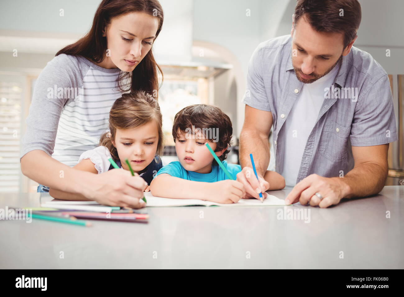 Family writing in book Stock Photo - Alamy