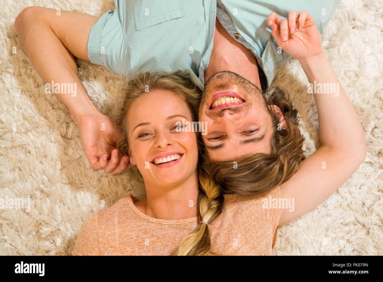 Cute couple resting on the carpet Stock Photo - Alamy