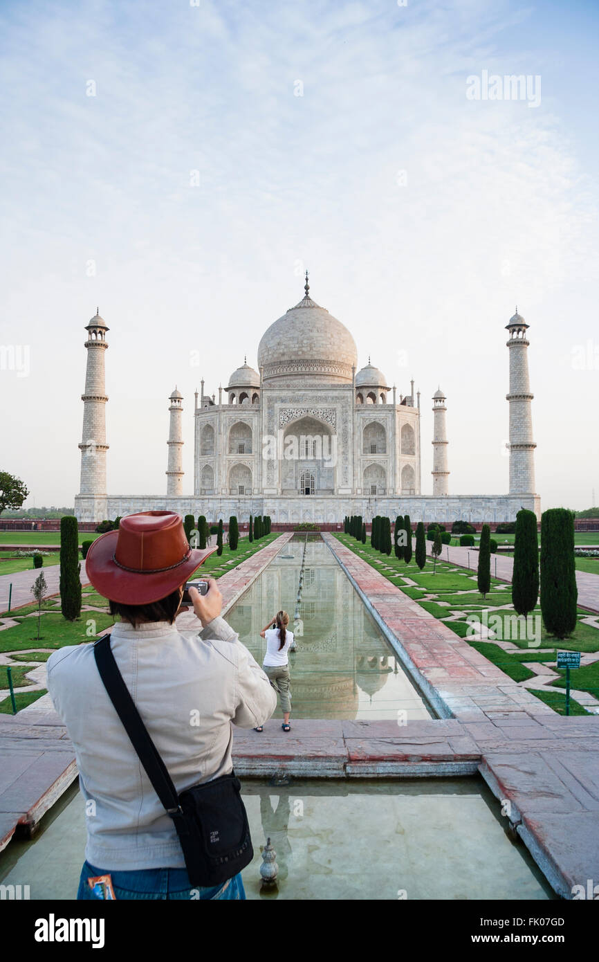 Agra, India. Male tourist in a red hat takes a picture of the Taj Mahal ...