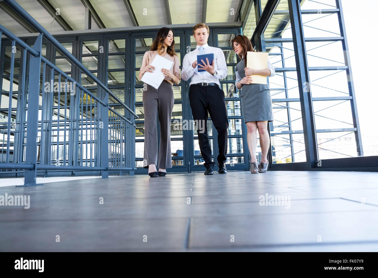 Three confident colleagues discussing in office Stock Photo - Alamy