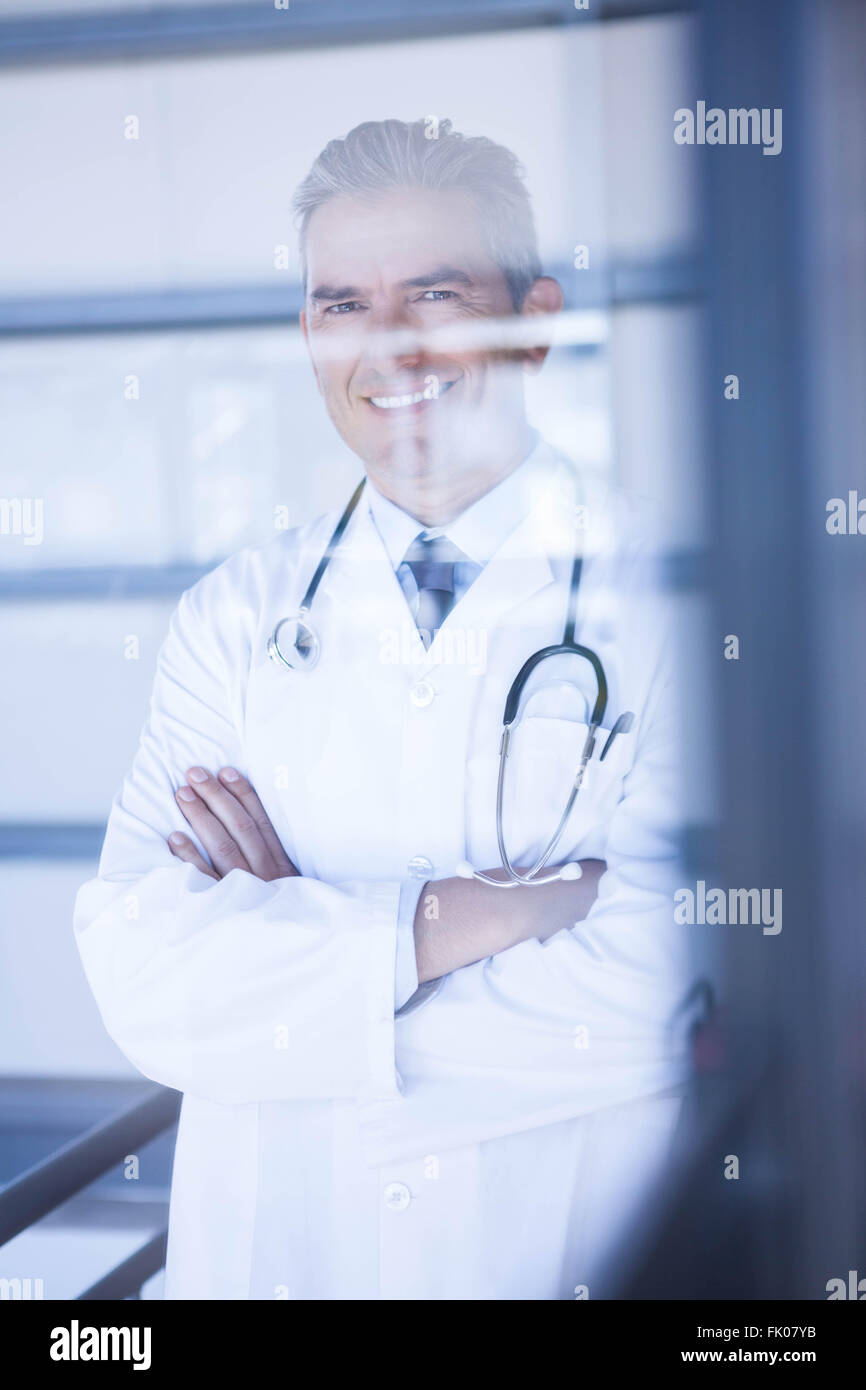 Happy male doctor standing with arms crossed Stock Photo - Alamy