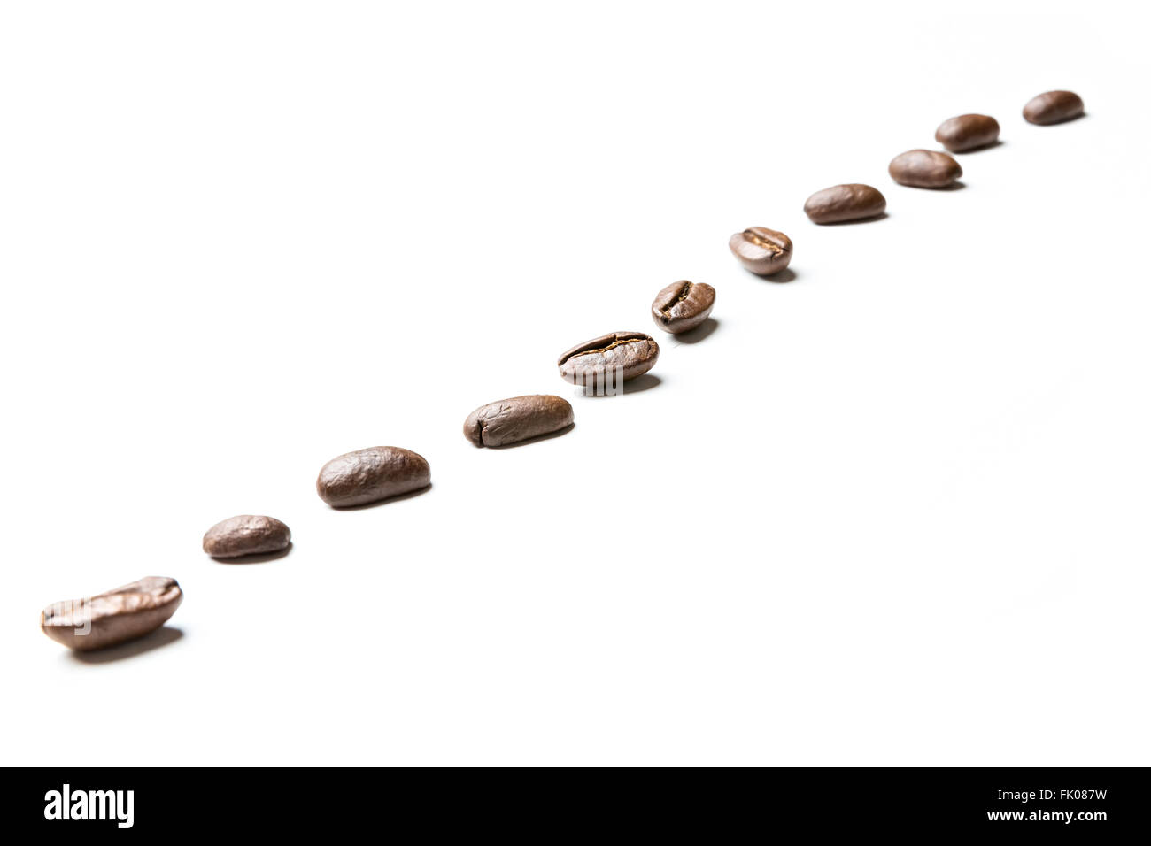 coffee beans in a row isolated on white background Stock Photo - Alamy