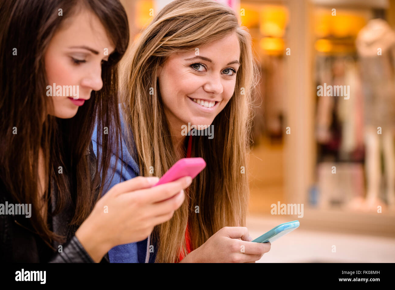Two beautiful women using their phone Stock Photo - Alamy