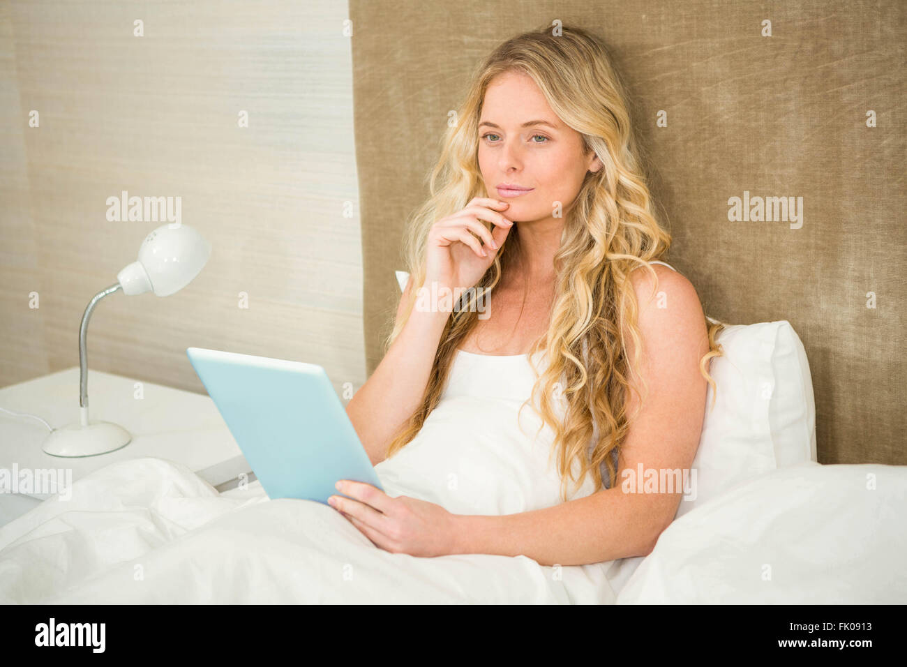 Pretty woman using tablet computer in her bed Stock Photo - Alamy
