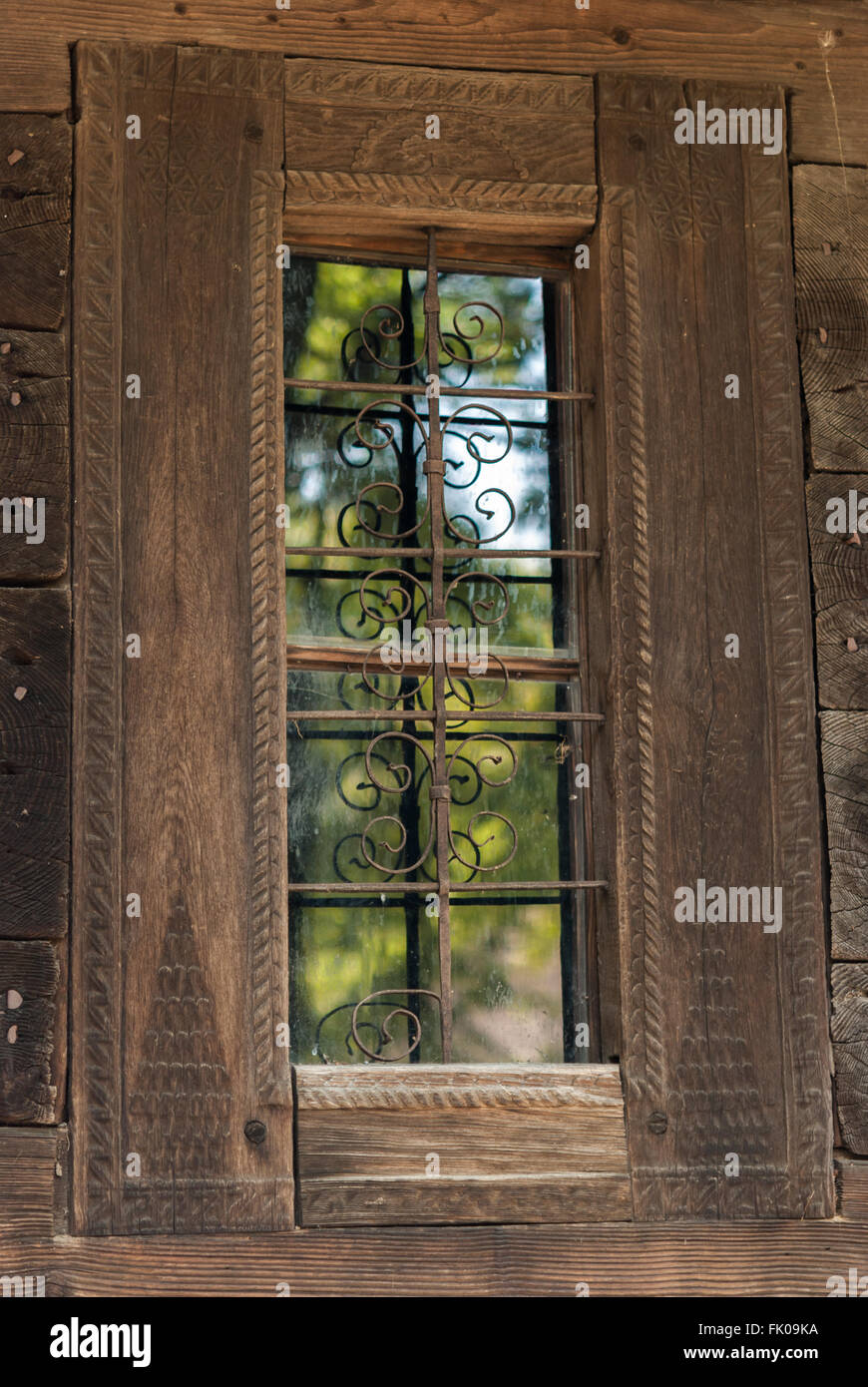 Old window with ornamented metal lattice in traditional wooden Romanian ...